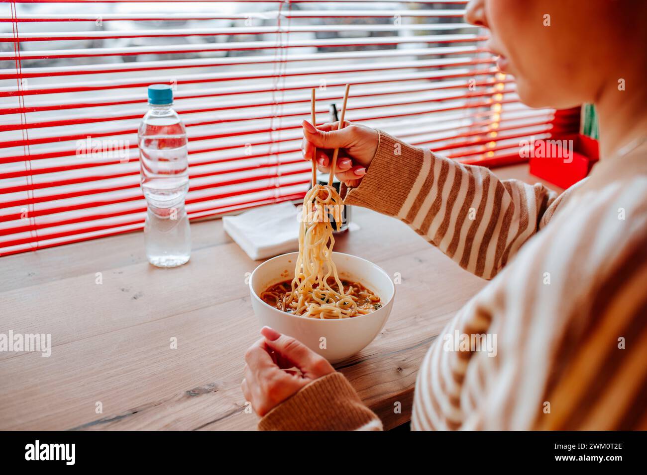 Woman eating ramen using chopsticks at cafe Stock Photo - Alamy
