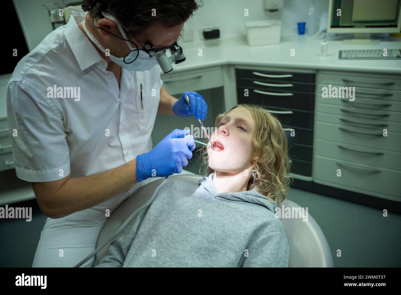 Dentist examining teeth boy boy at clinic Stock Photo - Alamy