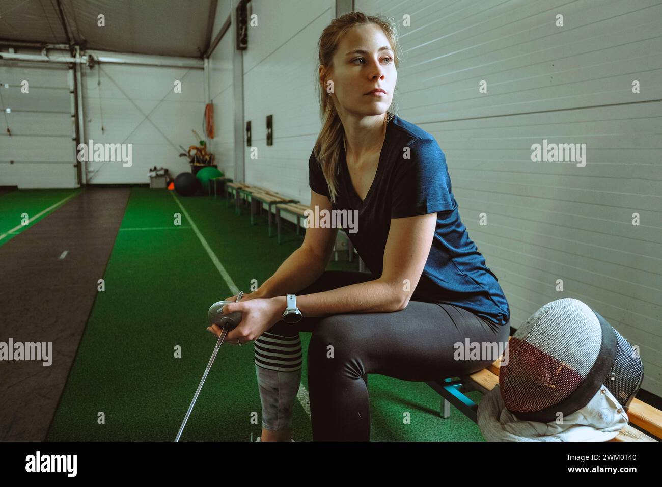 Woman in active wear sitting on bench in gym Stock Photo - Alamy