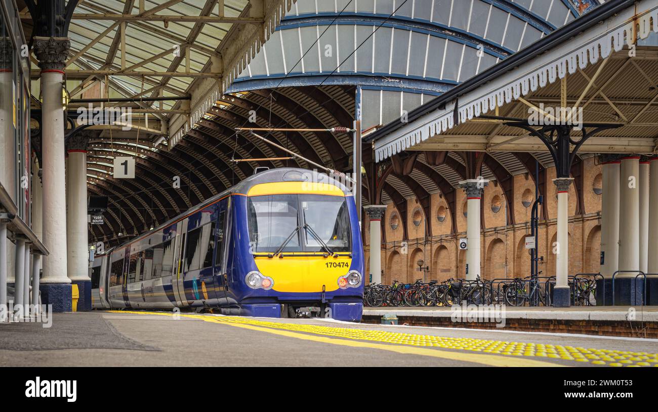 A train sits beside a historic 19th Century railway station platform ...