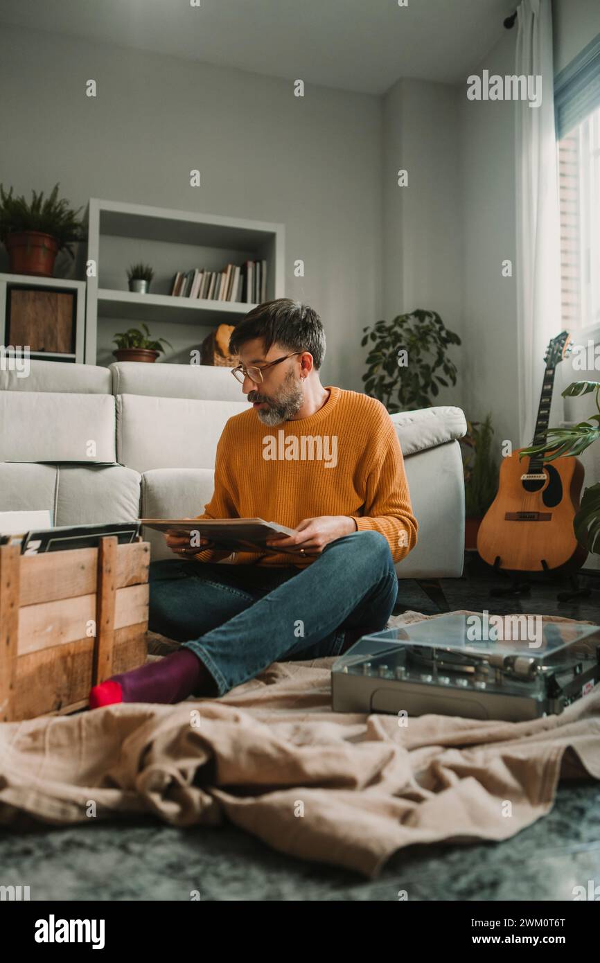 Man old-fashioned vinyl disc and record player at home Stock Photo - Alamy