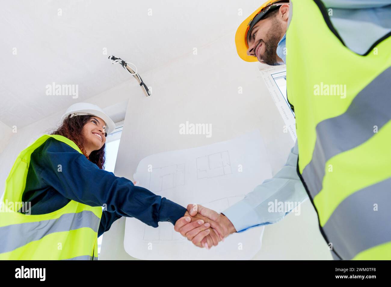 Young engineers doing handshake at construction site Stock Photo - Alamy