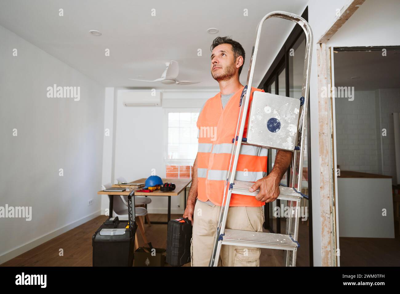 Maintenance engineer standing with work tool and examining house Stock ...