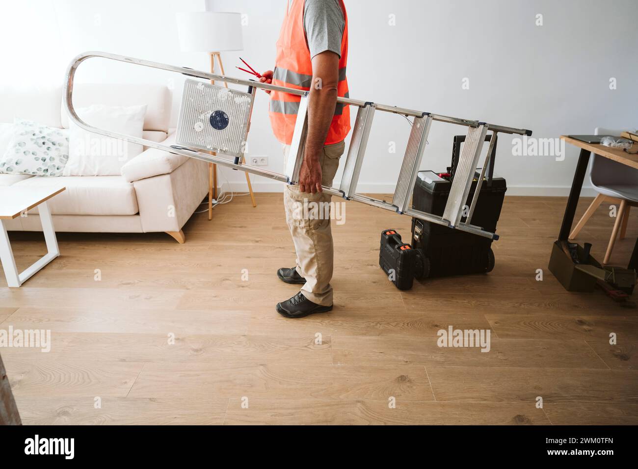 Technician standing with ladder at house under renovation Stock Photo ...