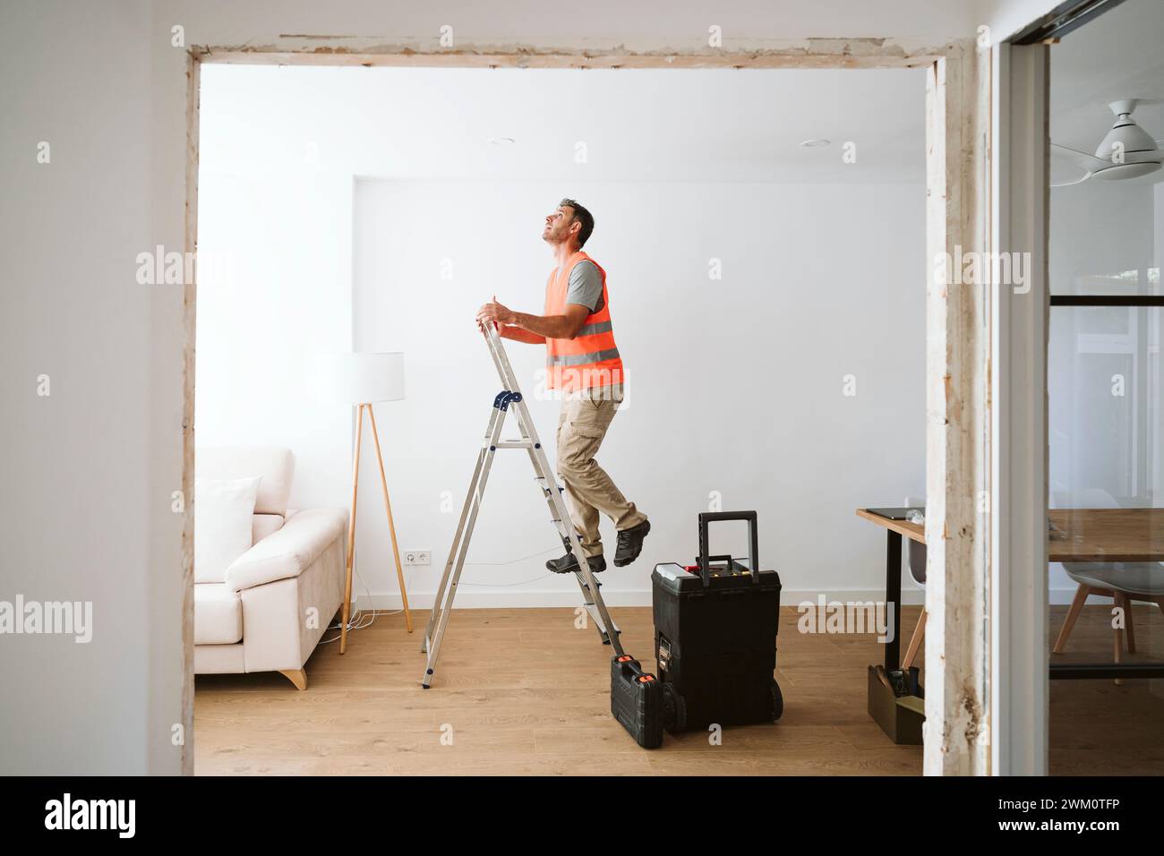 Technician climbing on ladder in house under renovation Stock Photo - Alamy