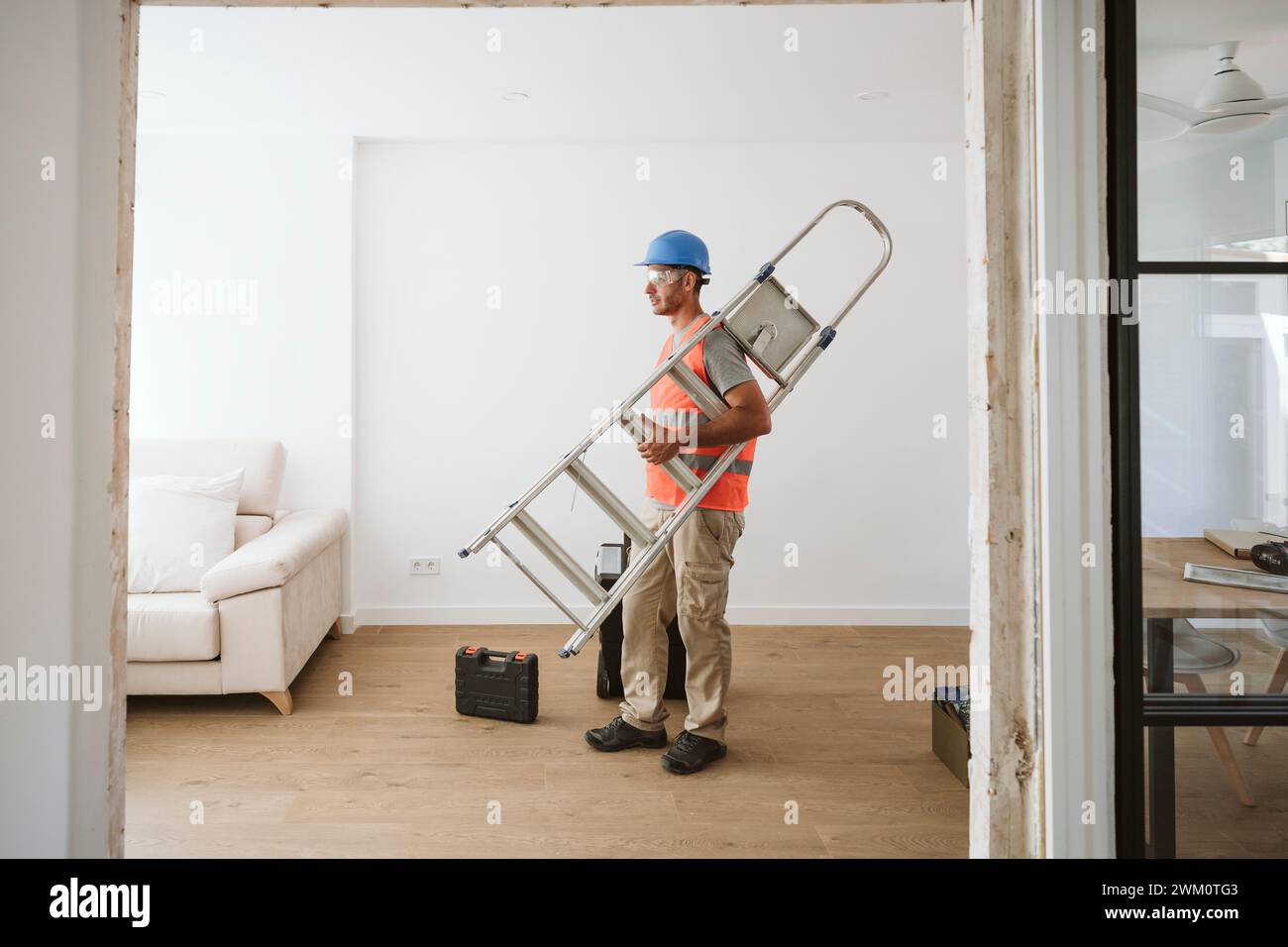 Maintenance engineer carrying ladder in house under renovation Stock ...