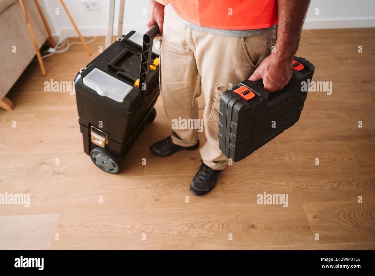 Repairman standing with tool boxes at house under renovation Stock ...