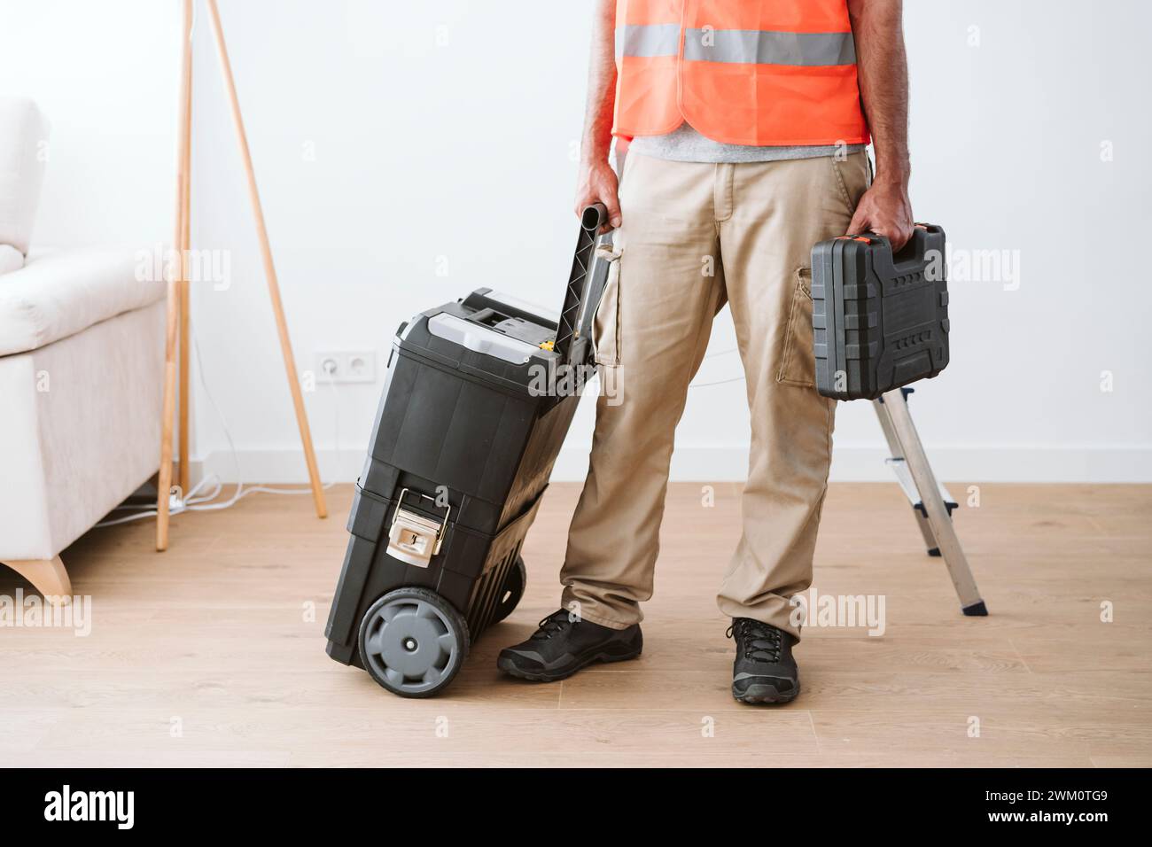 Technician standing with tool boxes at house under renovation Stock ...
