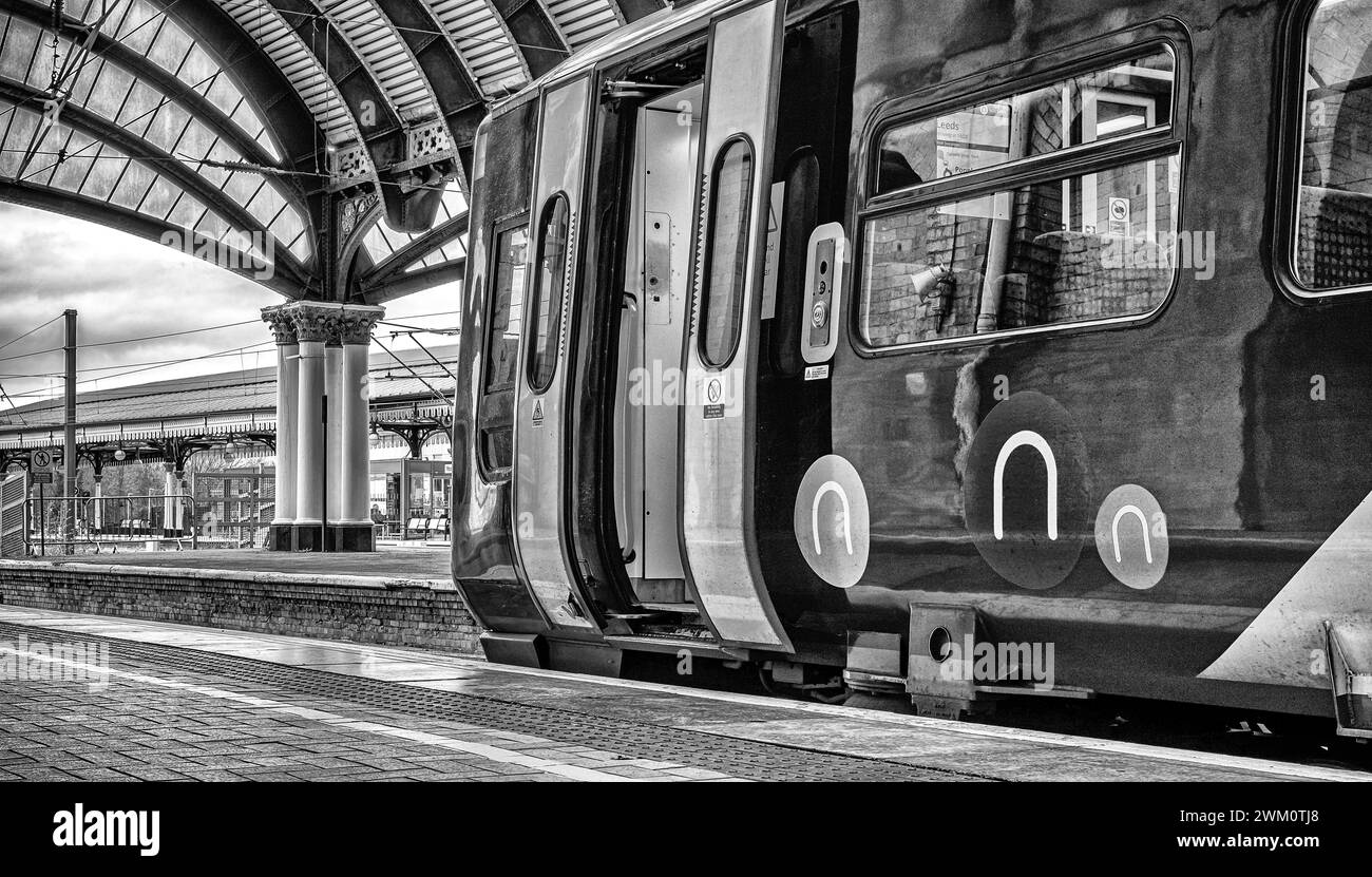 A railway train with its carriage door open prepares to depart ...