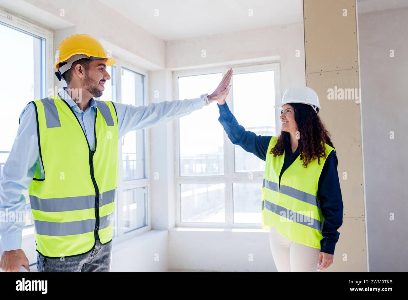Smiling architects giving high five at site Stock Photo - Alamy