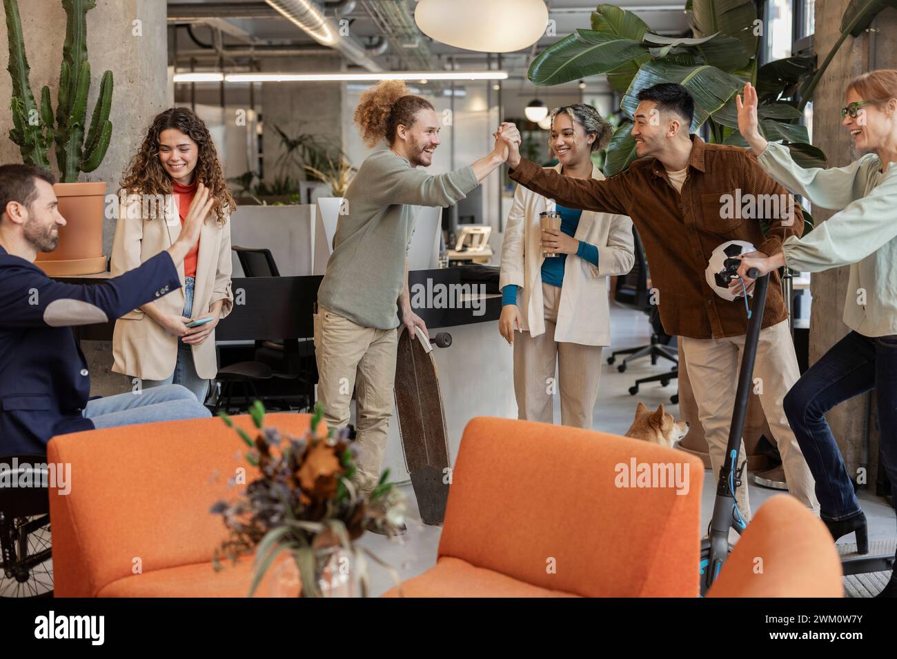 Happy diverse colleagues giving high-five to each other in meeting at ...