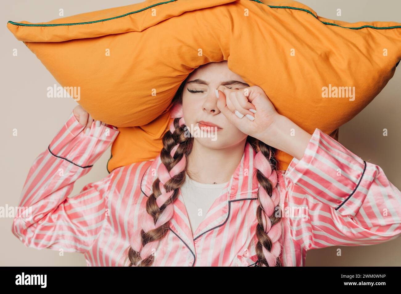 Tired woman with pillow over head standing near wall Stock Photo - Alamy