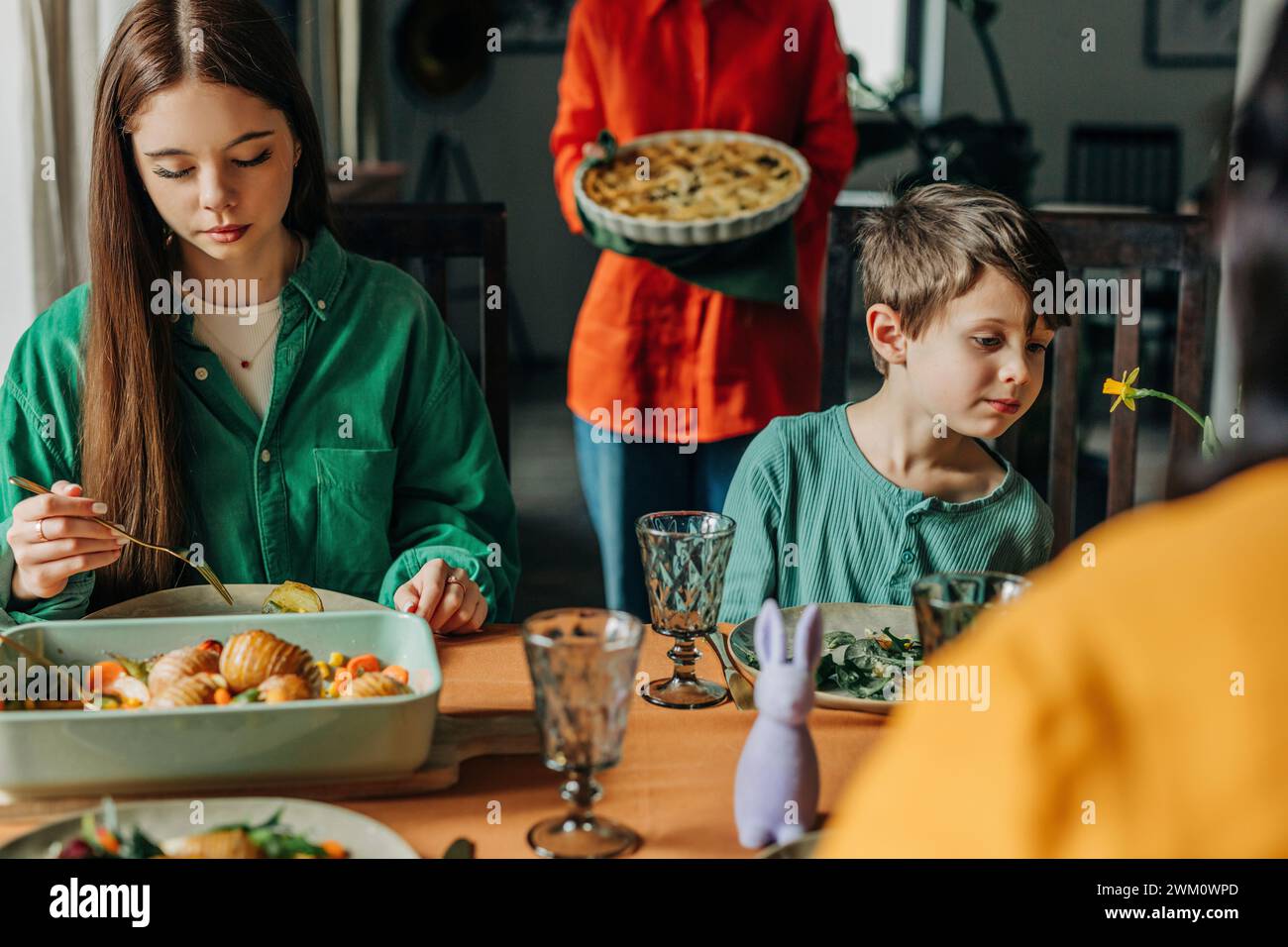 Siblings eating meal on dining table at Easter dinner celebration Stock ...