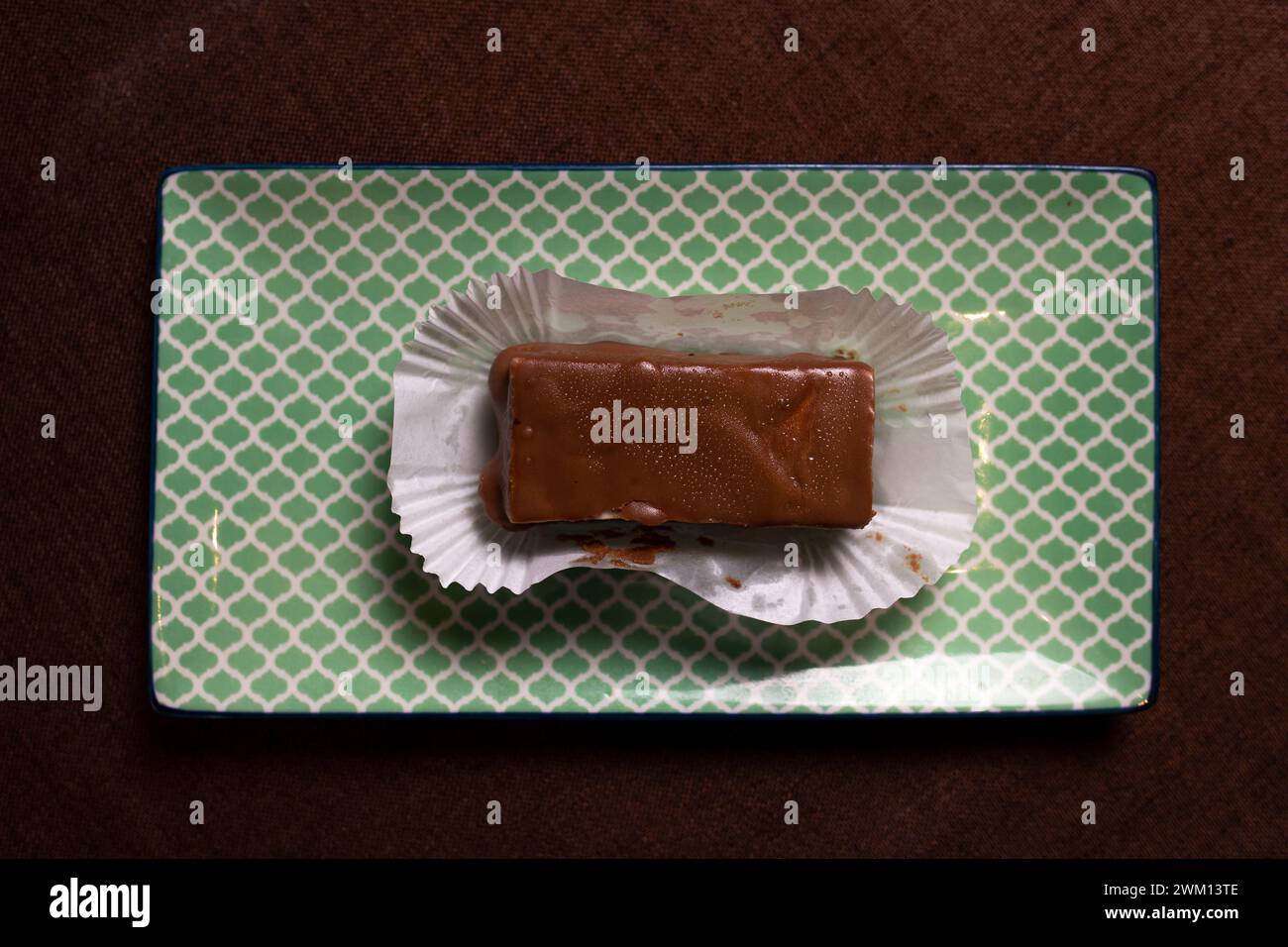 This image shows a piece of homemade chocolate fudge resting on a white ...