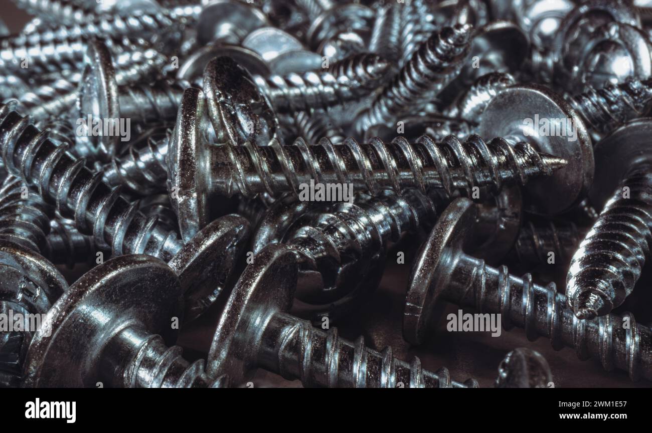 A bunch of metal screws on a black background. Metal screws background ...