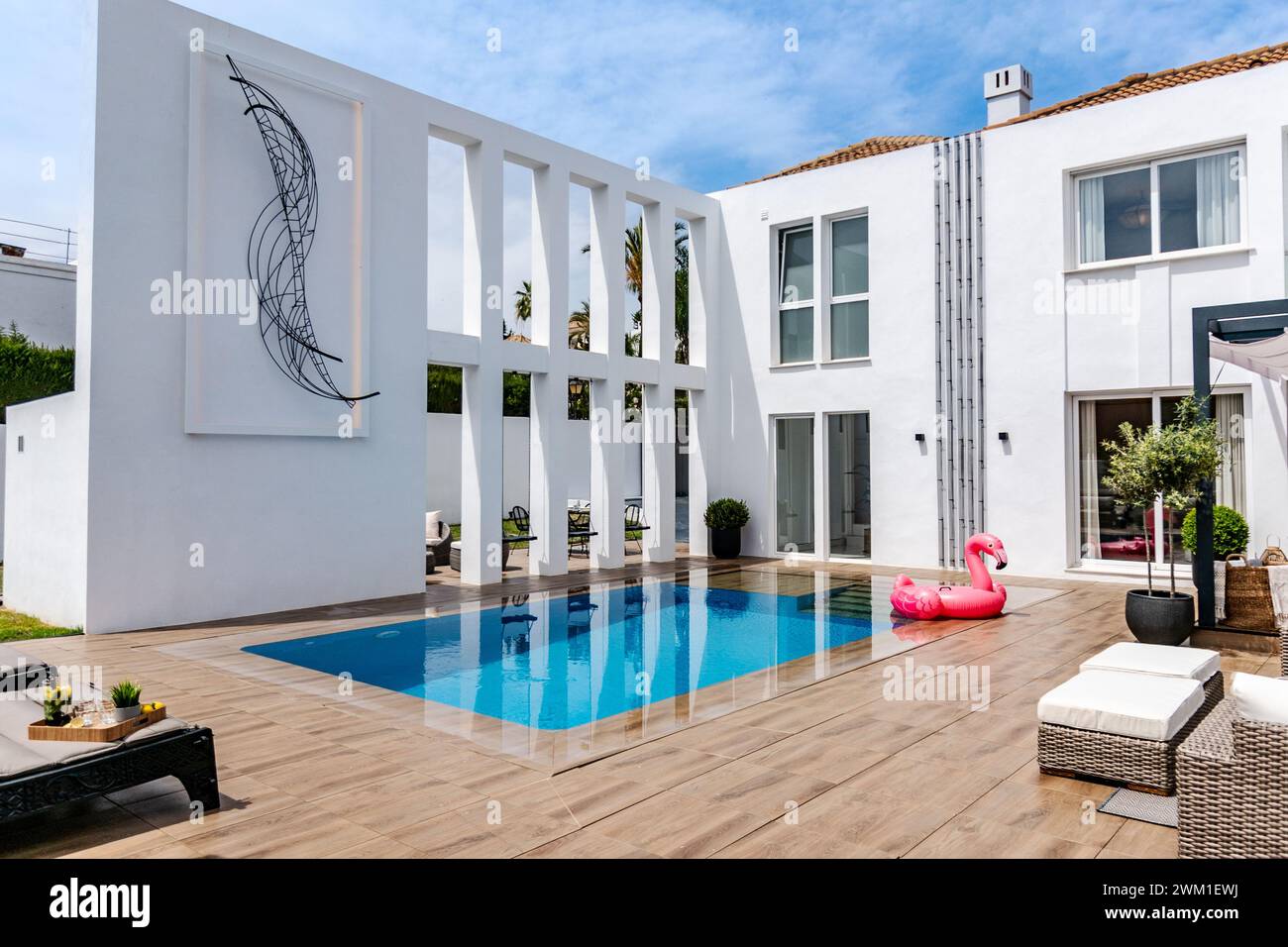 a poolside image overlooking an infinity swimming pool in the garden of ...
