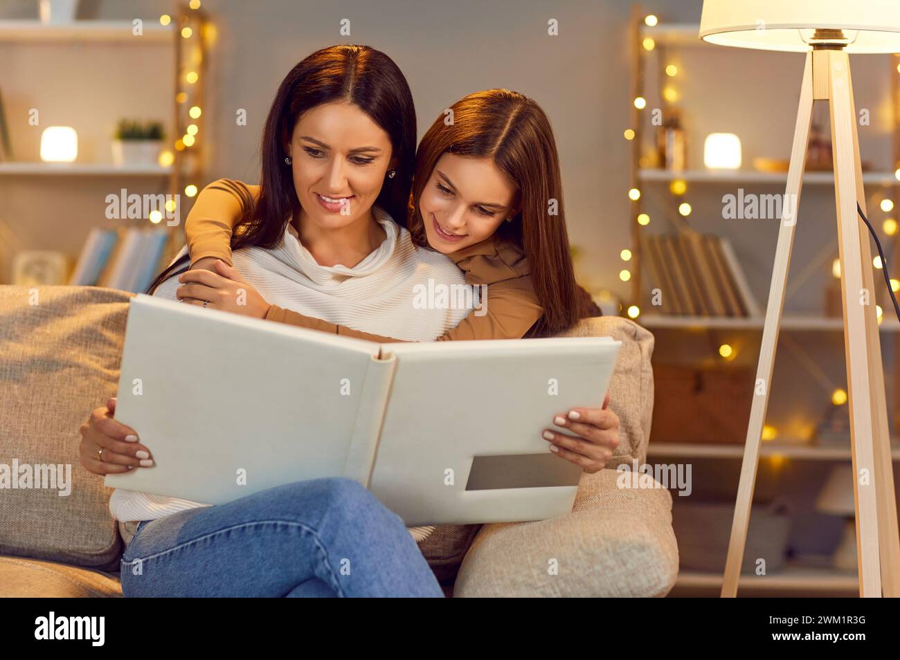 Mother and young daughter with photo album, family in love, happy ...