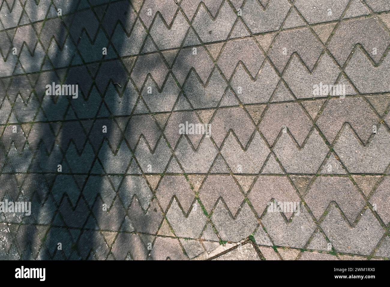 A detailed image of a rectangular grey brick walkway with a diagonal ...