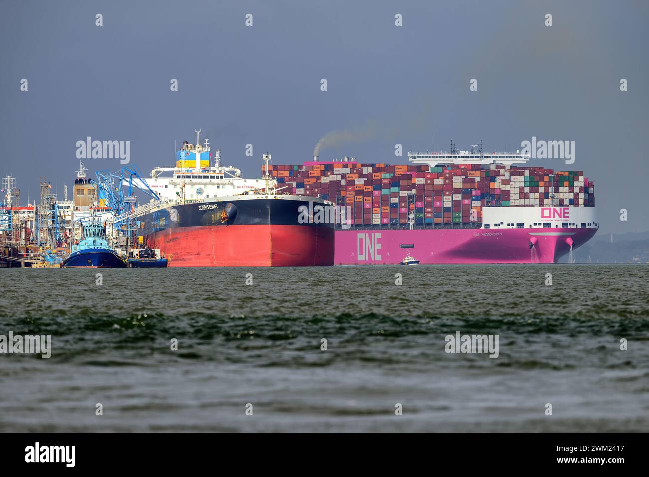 Shipping on Southampton Water. A container ship passing oil and gas ...