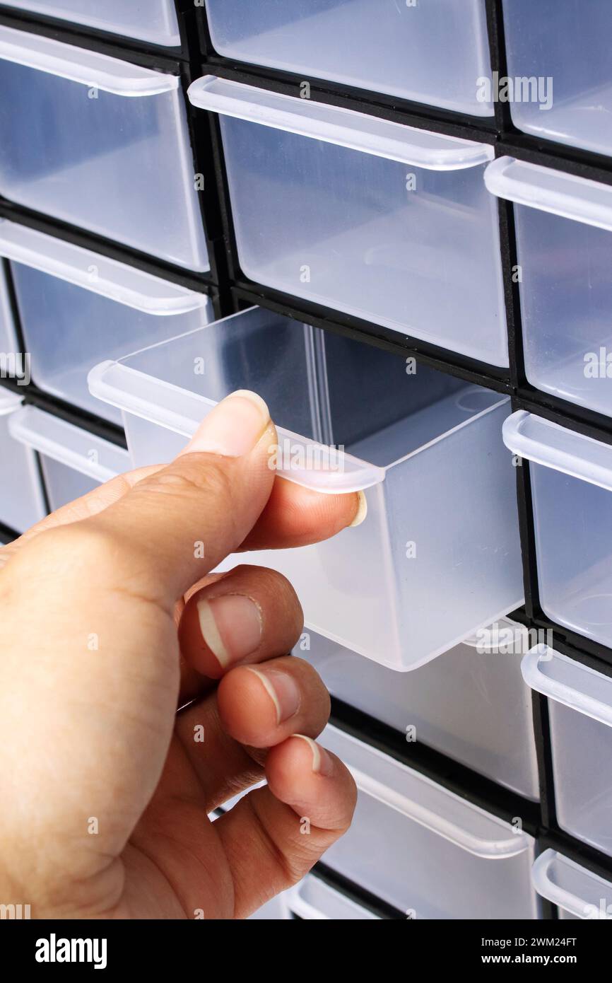 Plastic cells in the small change box and hand close up Stock Photo - Alamy