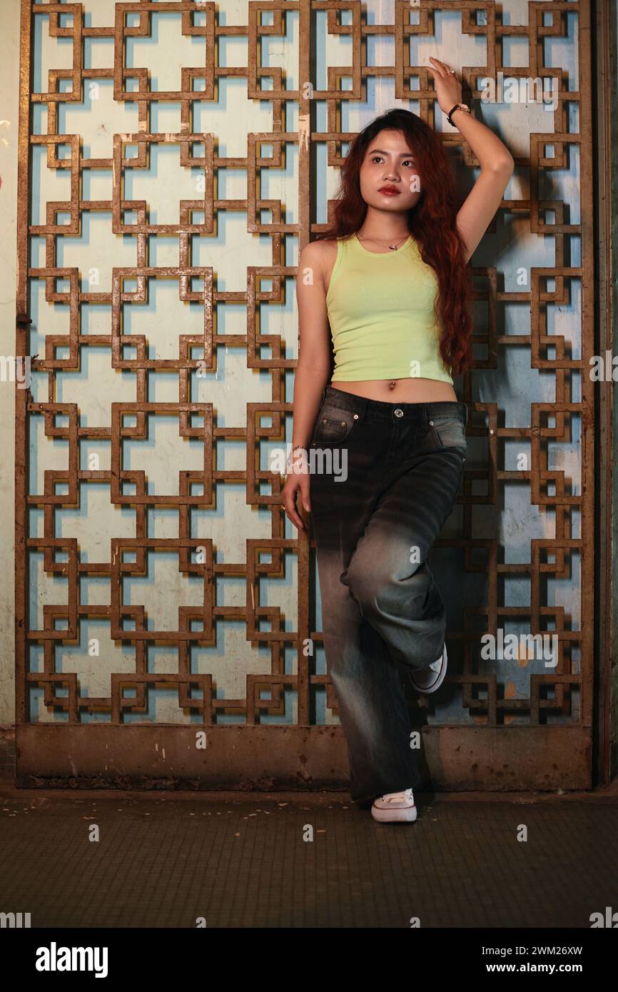 Young woman posing at painted decorative metal panel Stock Photo - Alamy