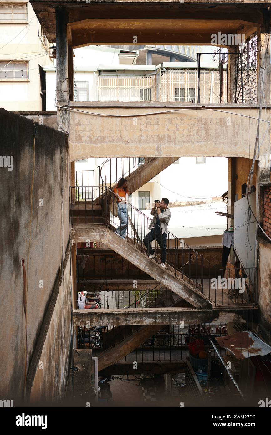 Coupe photographing on staircase of shabby building in old town area ...