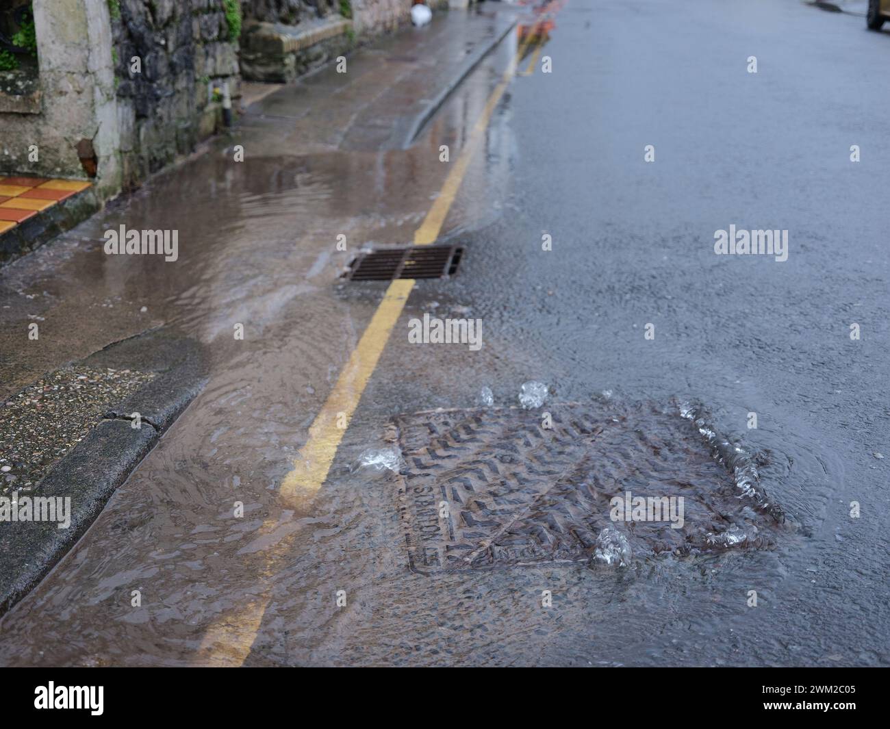 February 2024 - Water gushing up out of a manhole cover on a wet day on ...