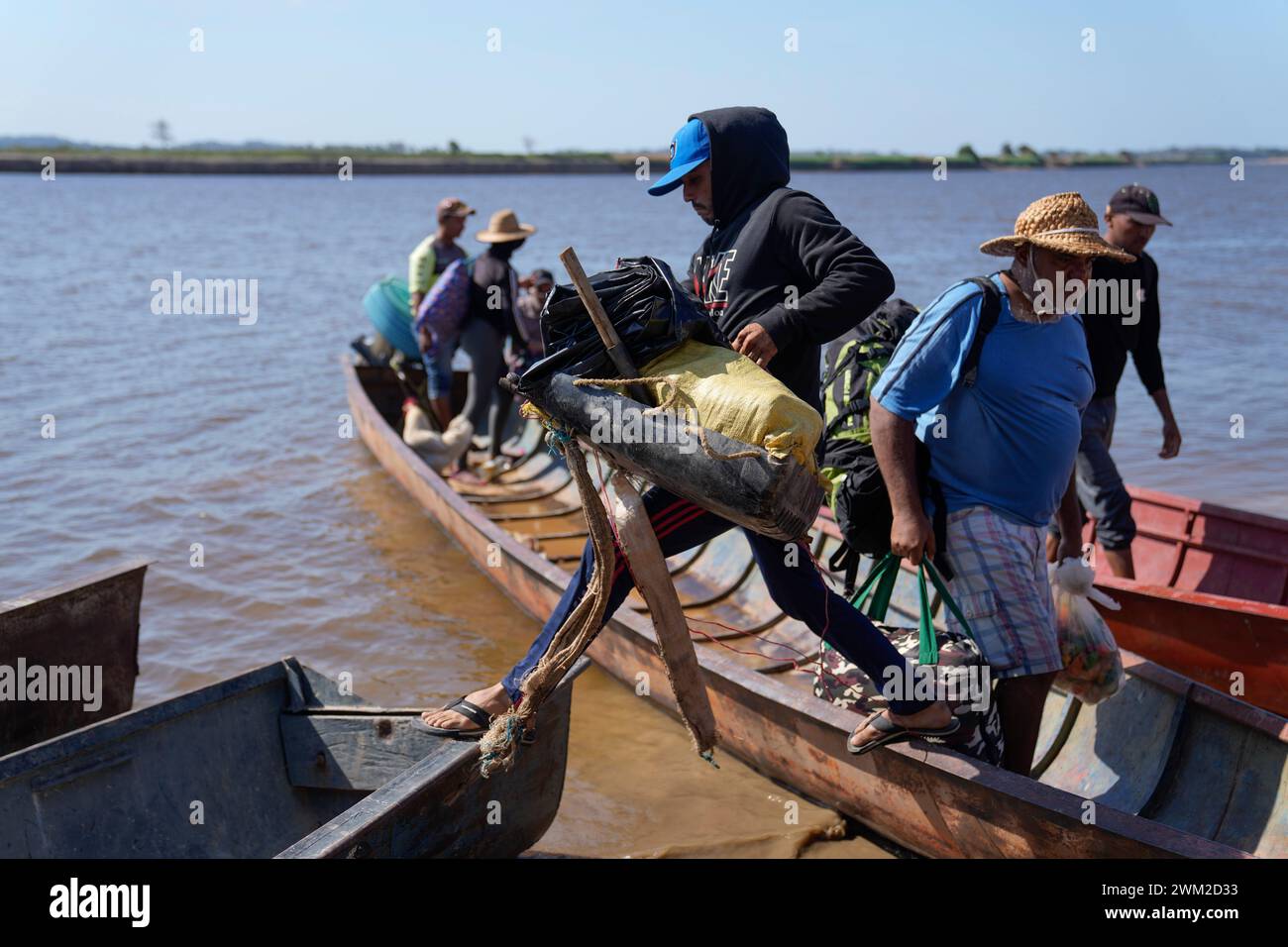 People arrive by boat after leaving La Bulla Loca mine, which collapsed ...