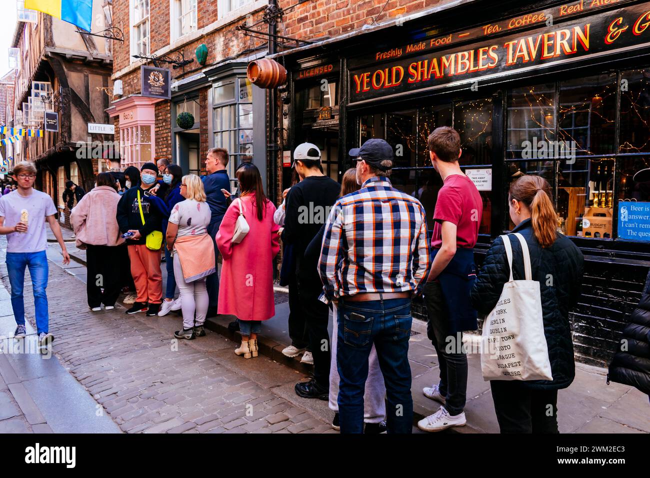 Queue of people waiting to buy chocolate in a store. The Shambles. York ...