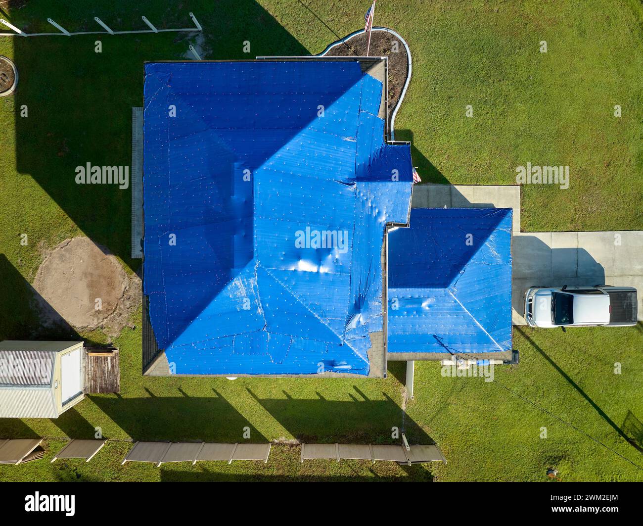 Aerial view of damaged in hurricane Ian house roof covered with blue ...