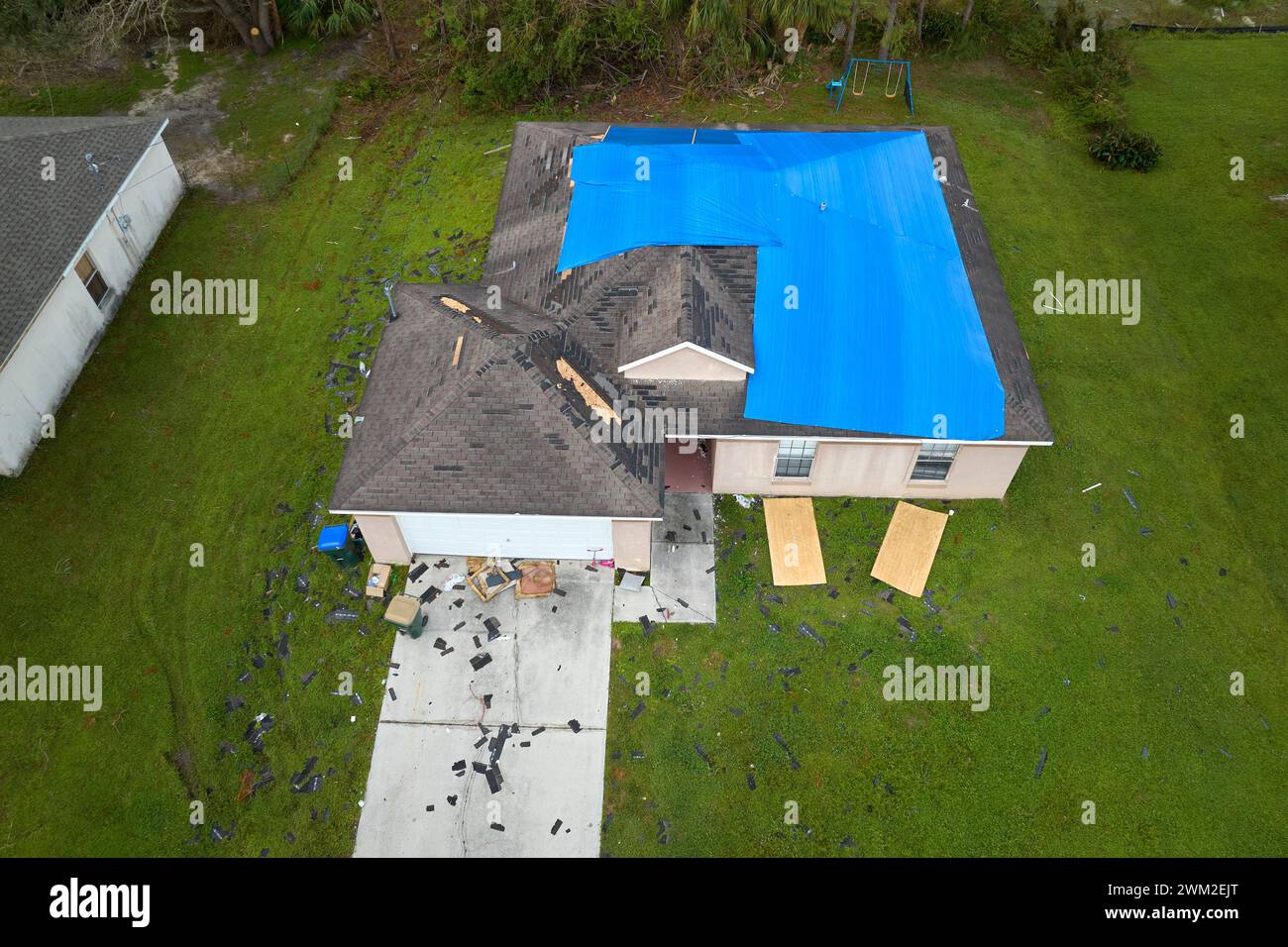 Aerial view of damaged in hurricane Ian house roof covered with blue ...