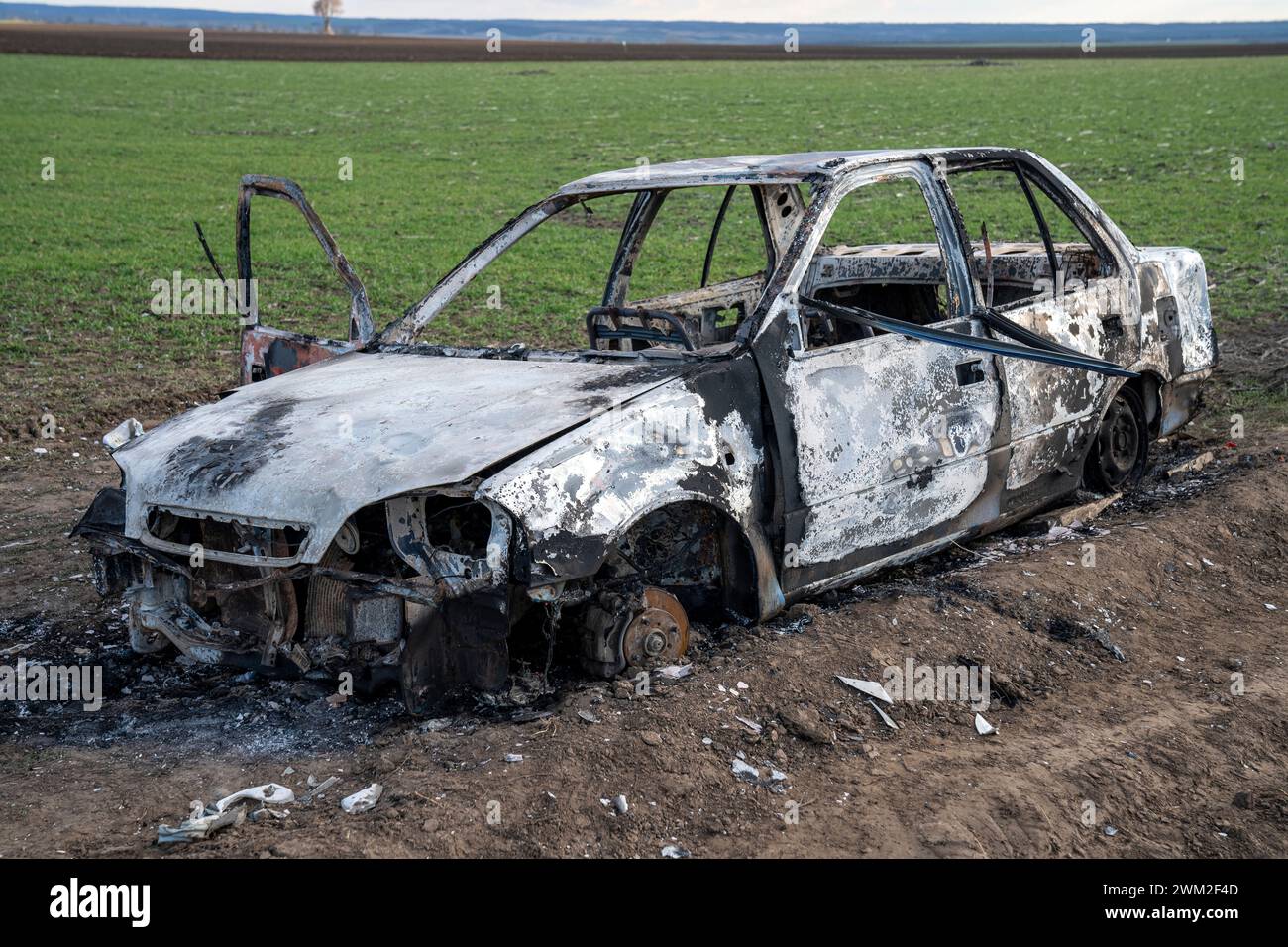A burned out car. Burnt car in the field. Car fire, vehicle fire due to ...