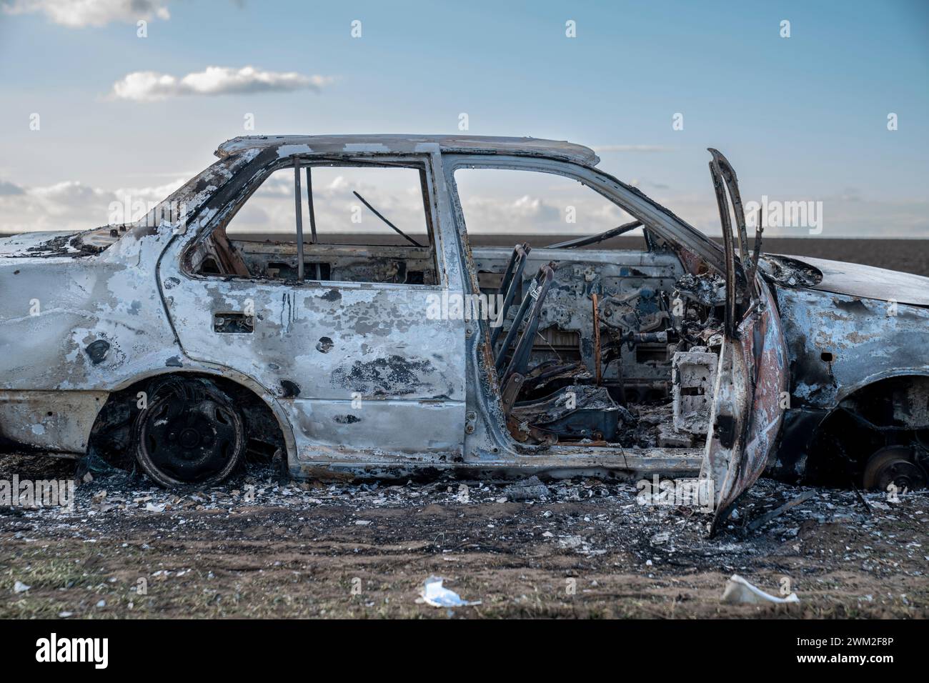 A burned out car. Burnt car in the field. Car fire, vehicle fire due to ...