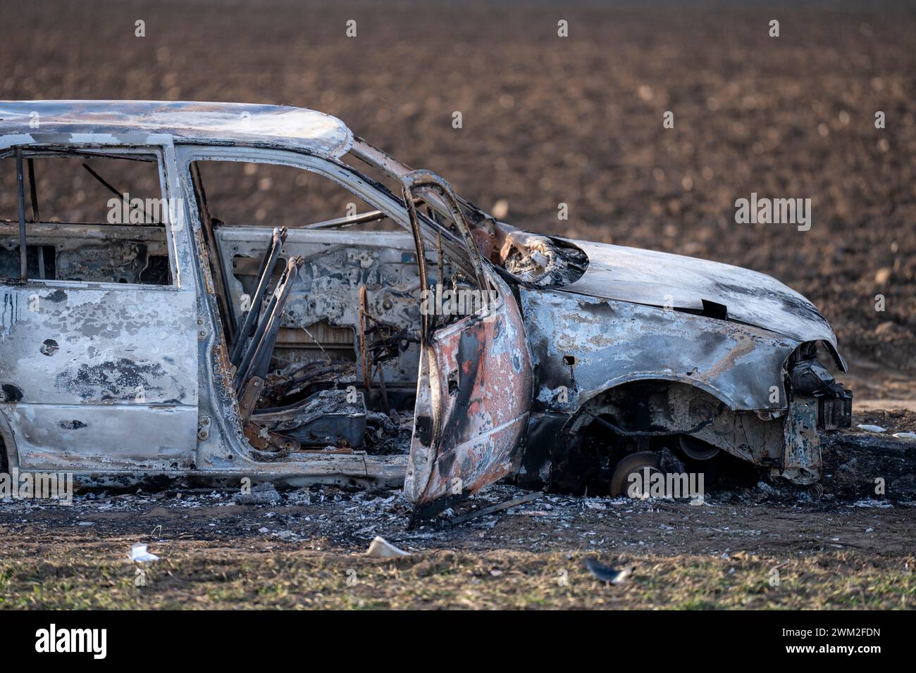 A burned out car. Burnt car in the field. Car fire, vehicle fire due to ...