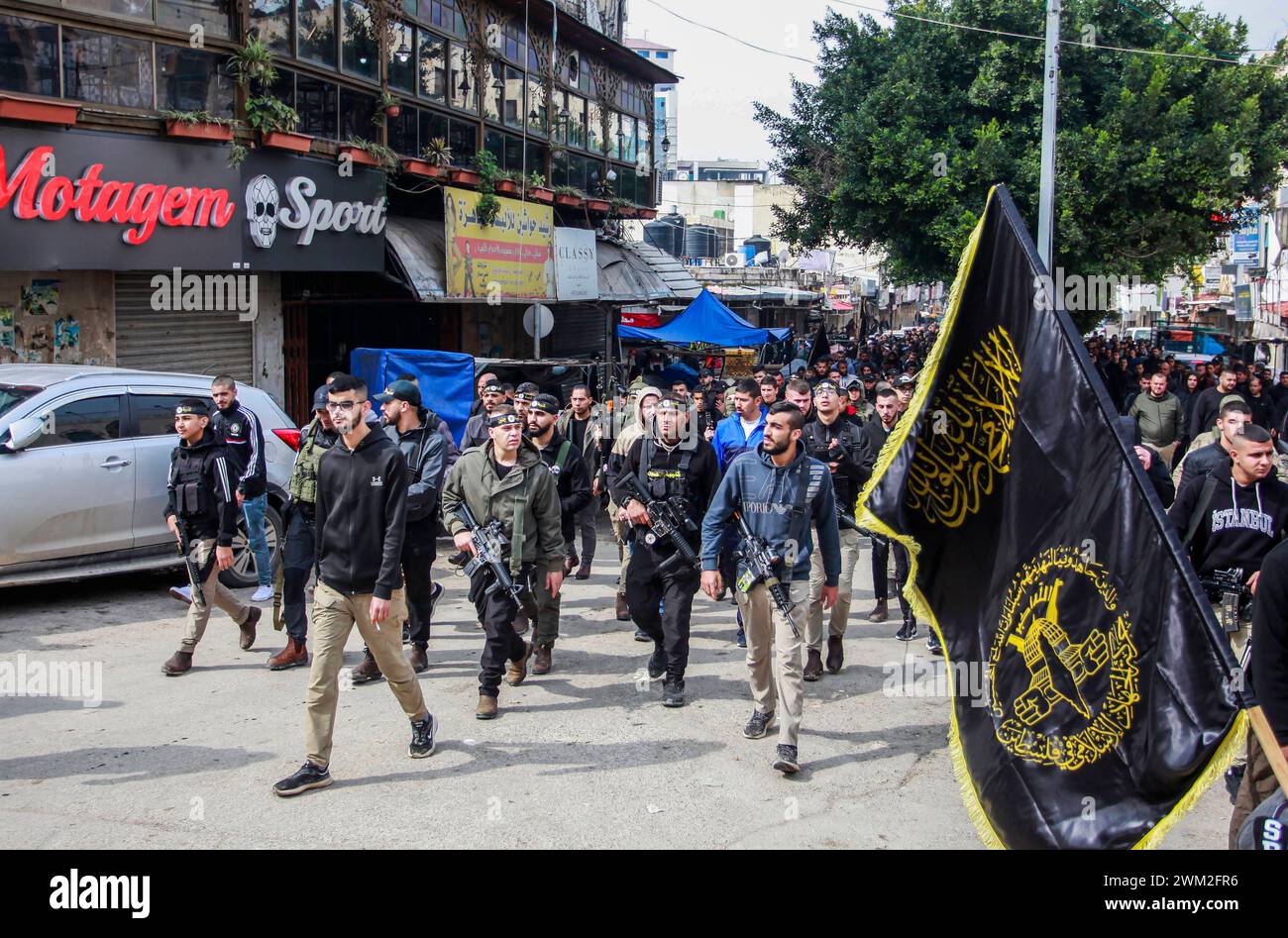 Jenin, Palestine. 23rd Feb, 2024. Gunmen march ahead of the bodies of ...