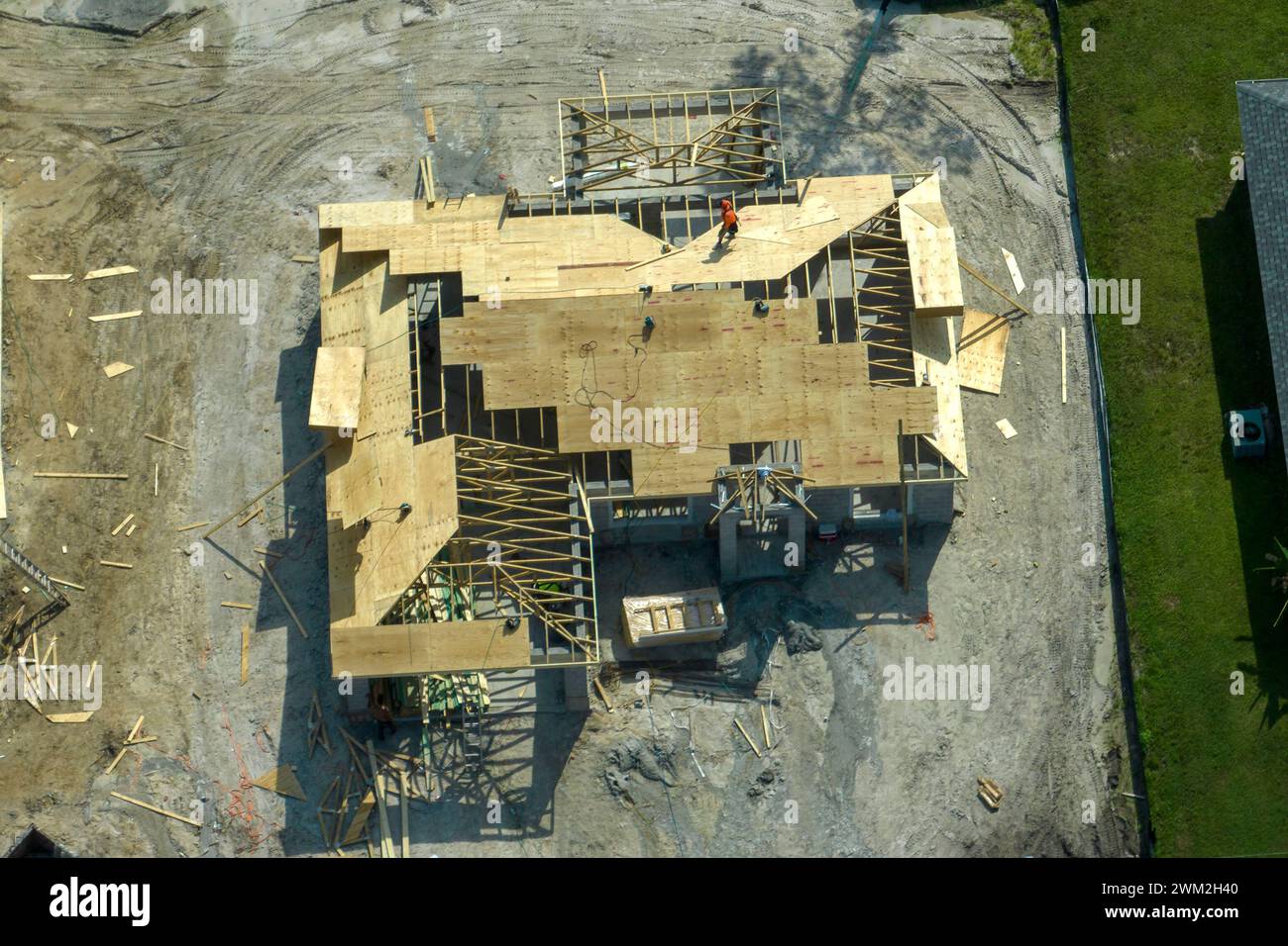 Builders working on roof construction of unfinished residential house ...