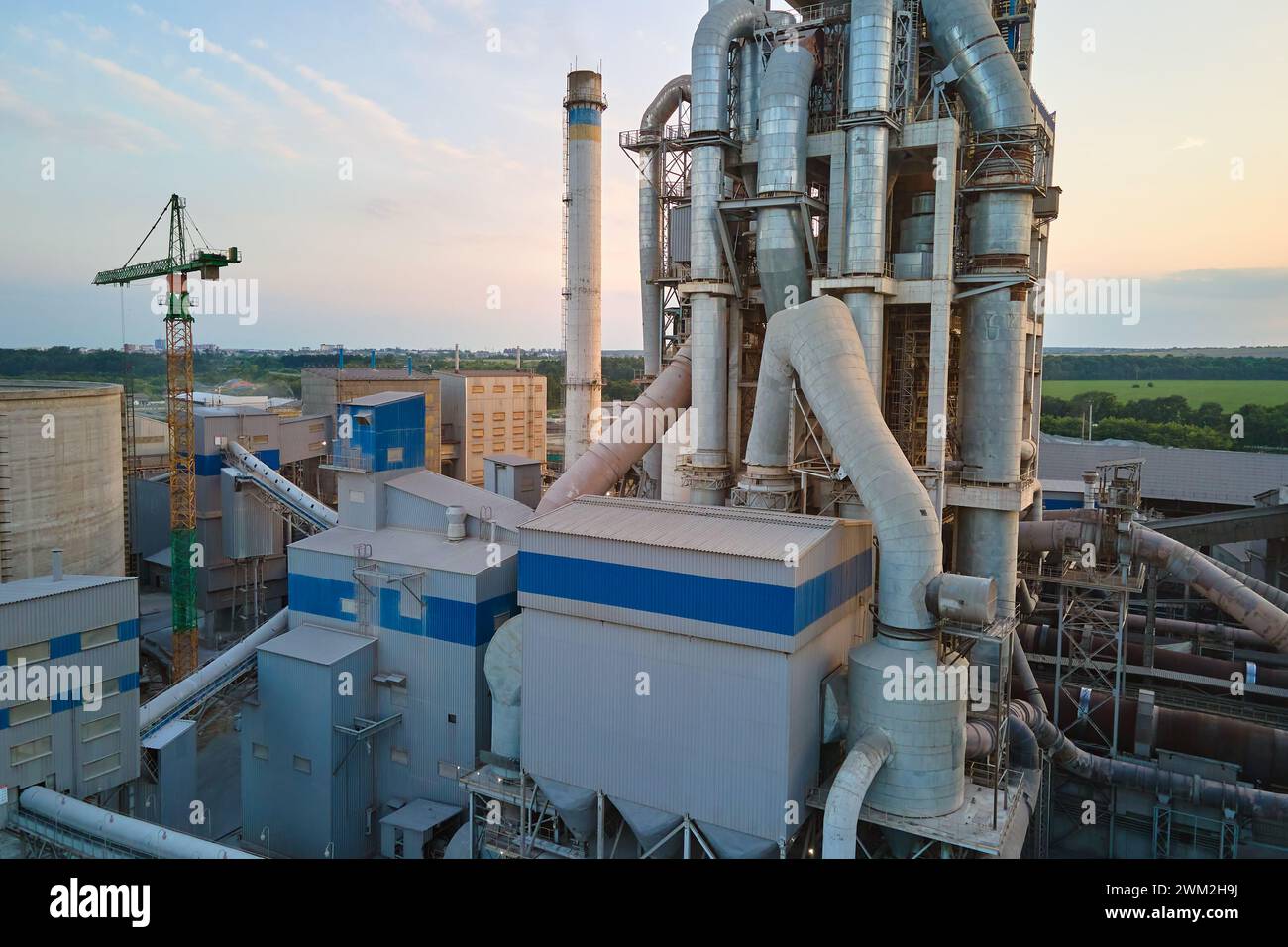 Cement plant with high factory structure and tower cranes at industrial ...