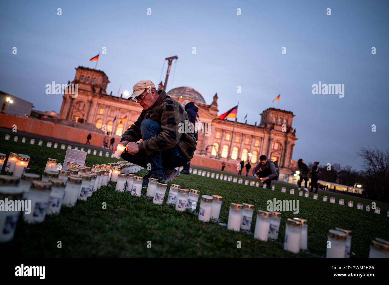 Berlin, Germany. 23rd Feb, 2024. A person lights a candle in front of ...