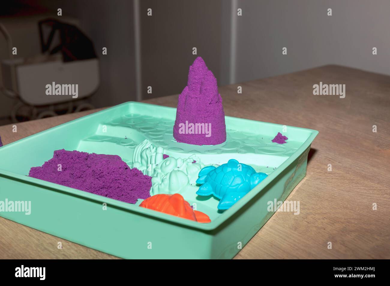 A child is using their fingers to create art with violet and magenta ...