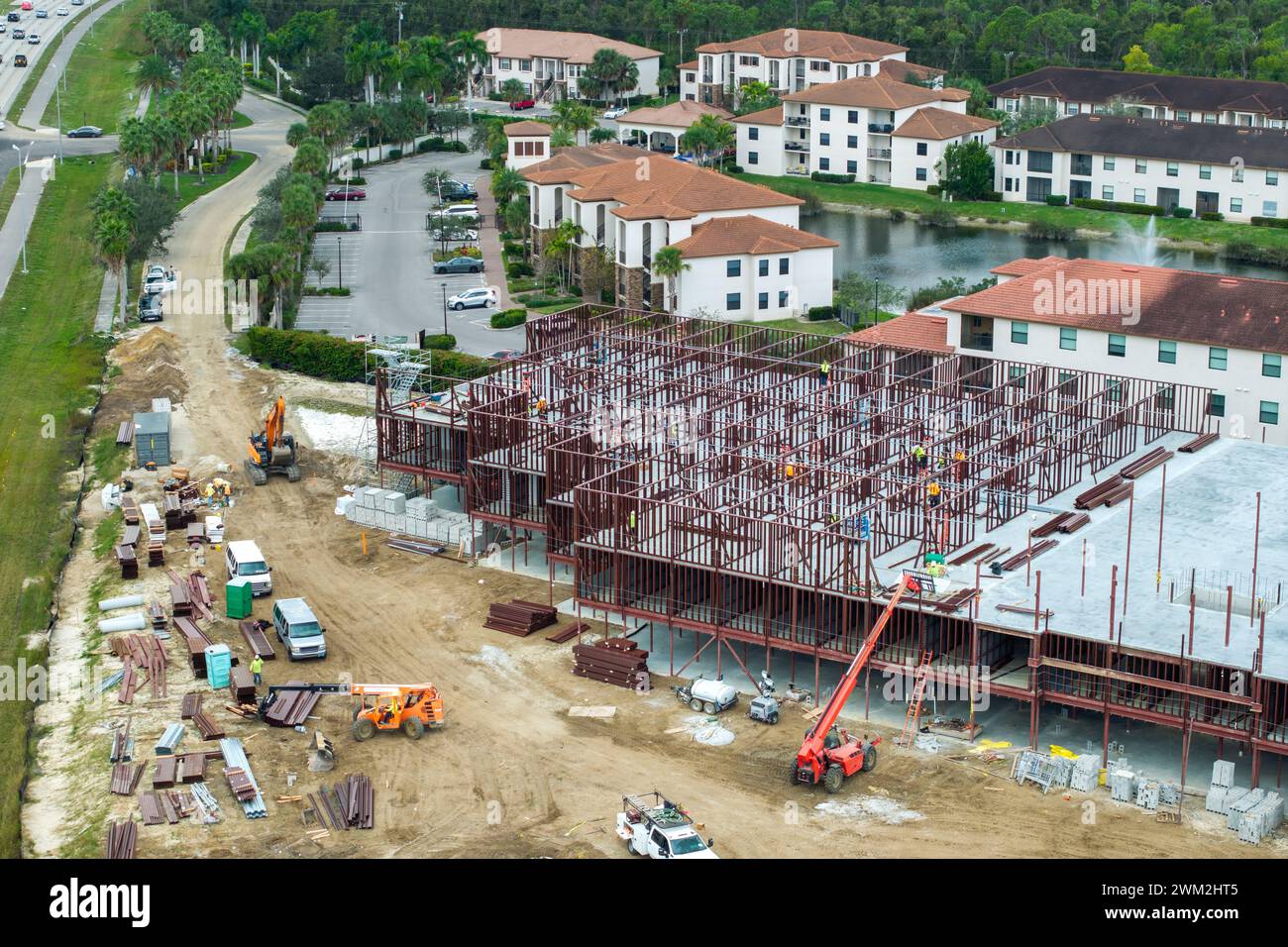 Construction works on metal walls of commercial building. Blue collar ...