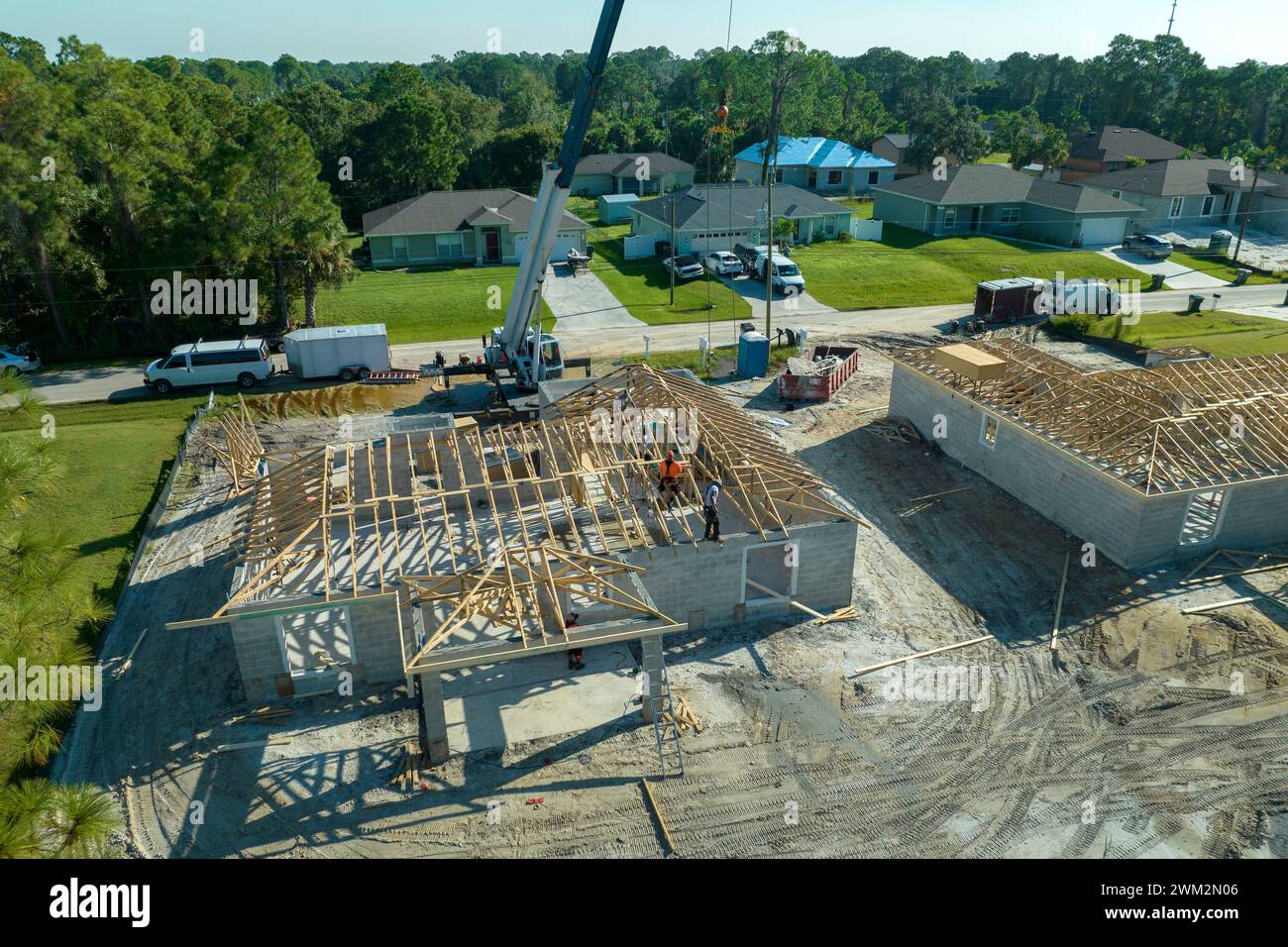 Professional builders and crane truck working on roof construction of ...