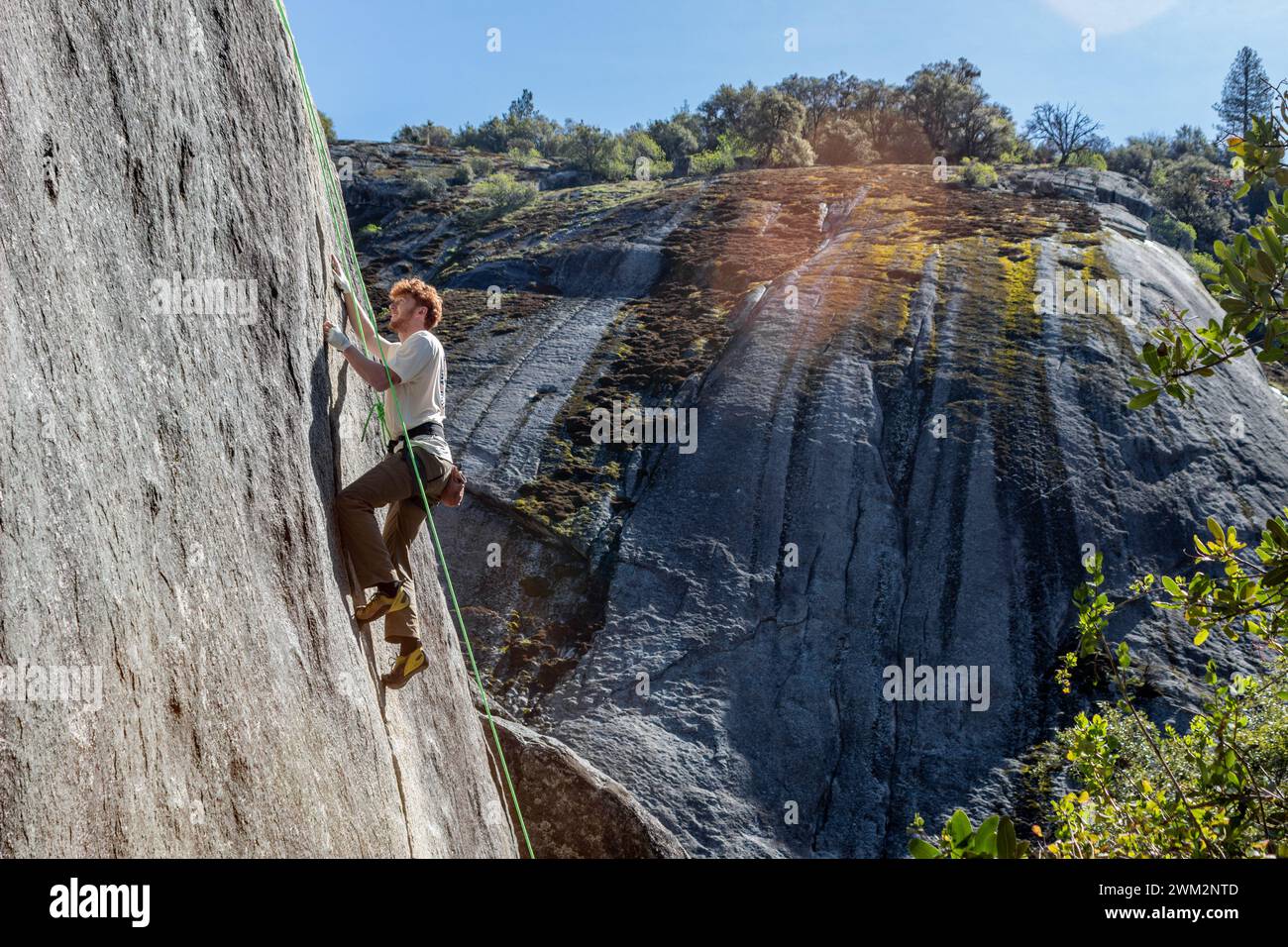 Rock Climber climbing a route on granite in Placerville California ...