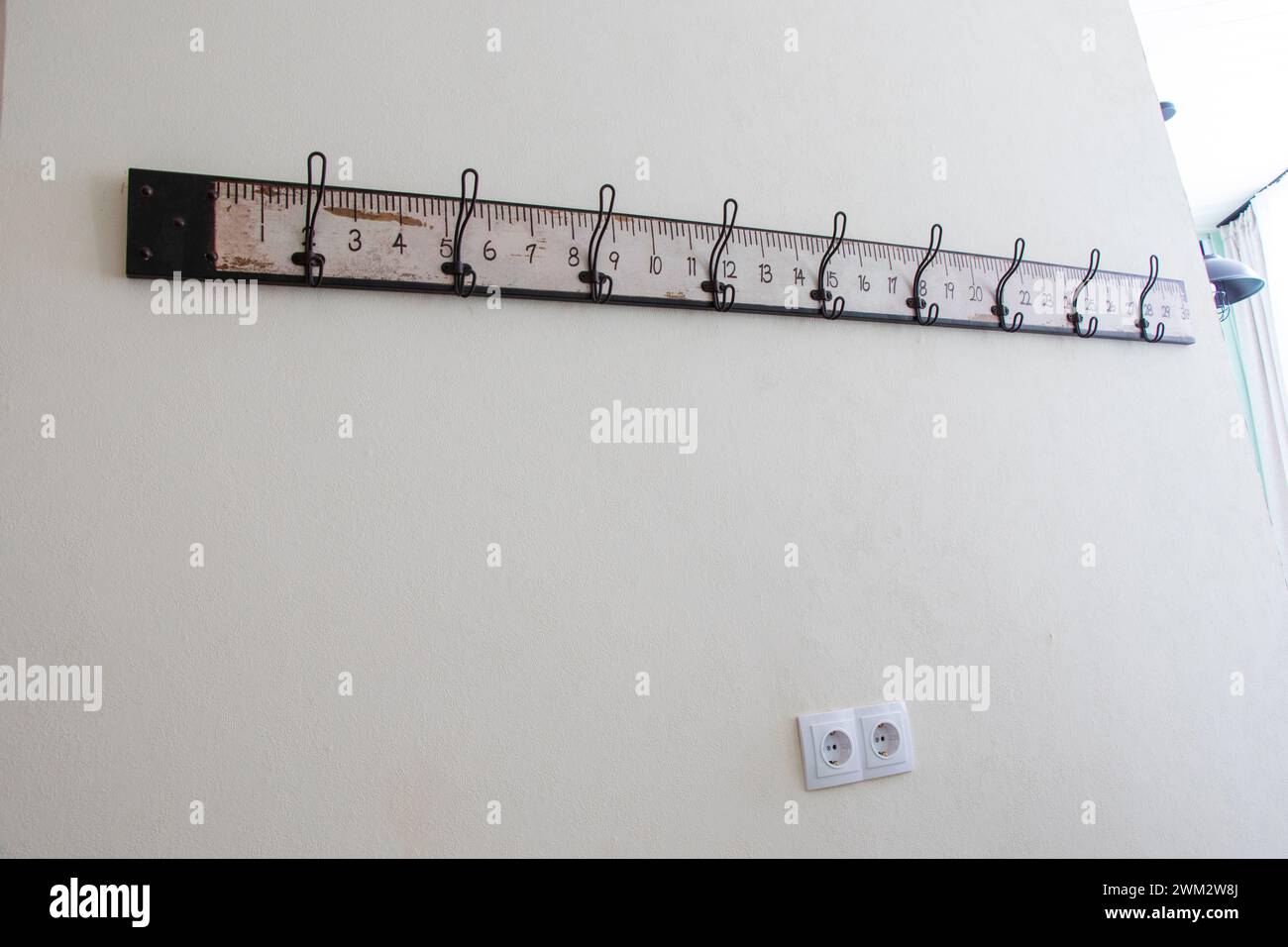 A slim ruler suspended above a doorway on a wall Stock Photo - Alamy