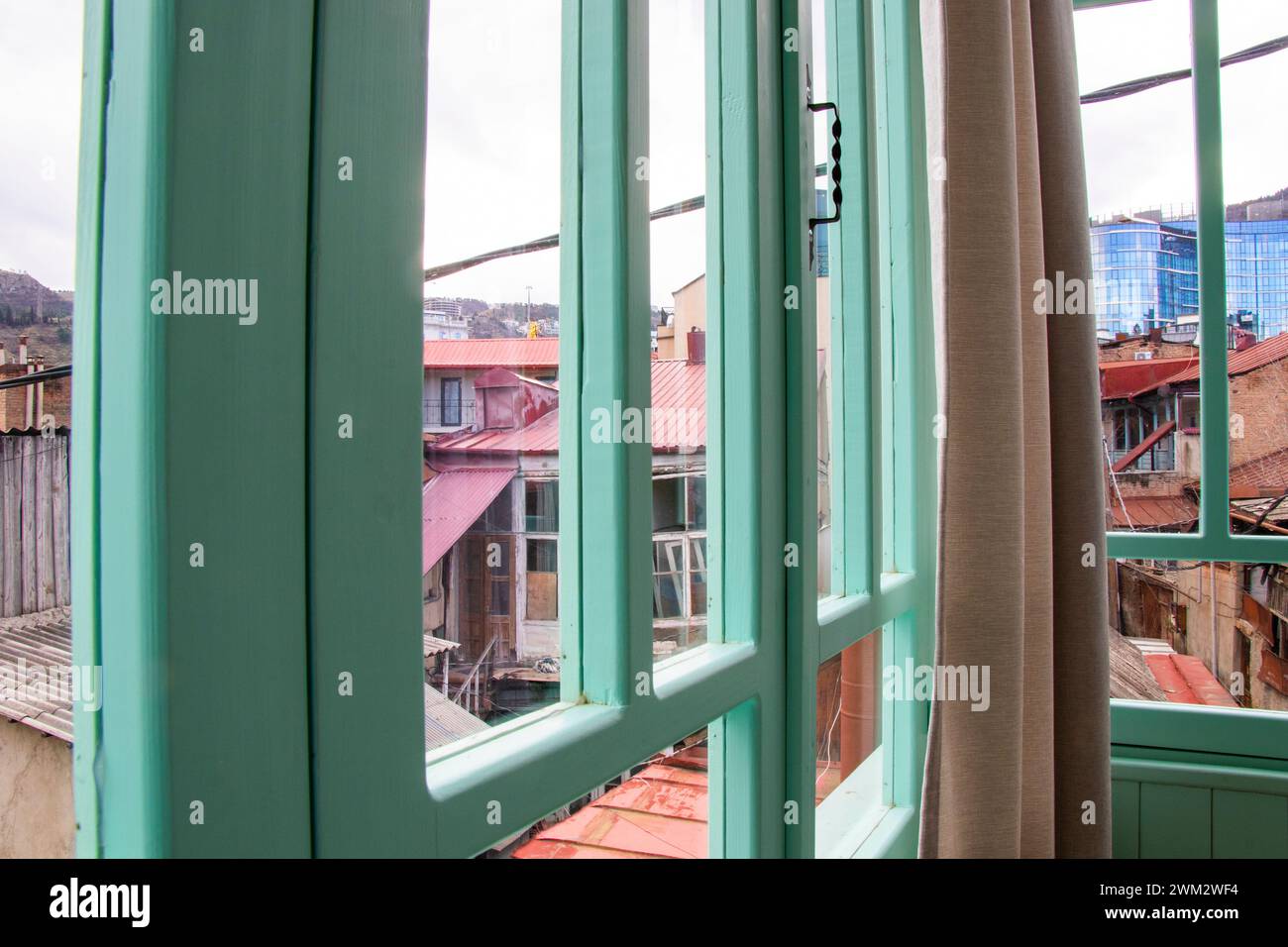 A window with curtains framing a city view Stock Photo - Alamy