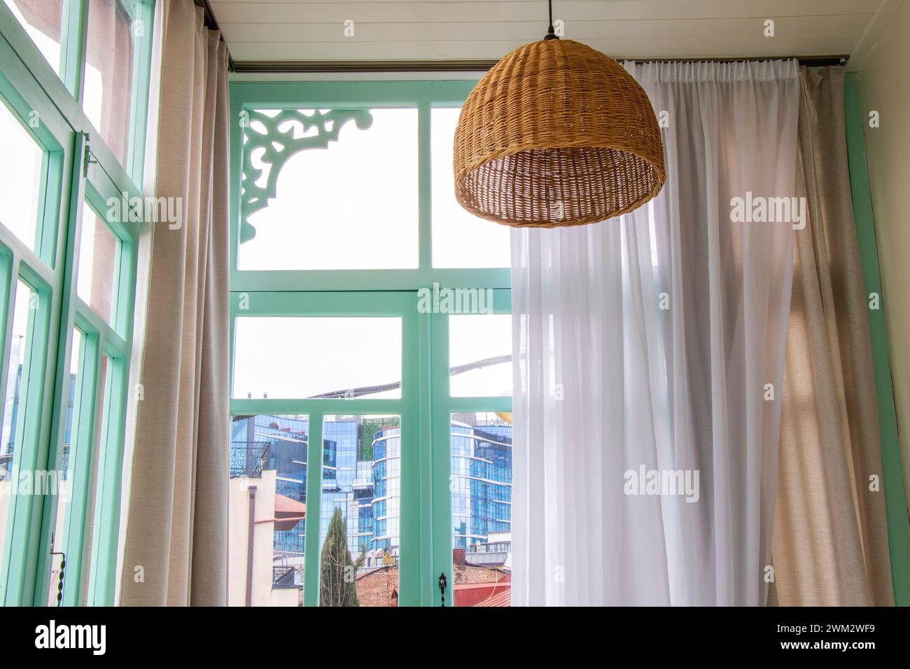 Bed and table by large window with curtains in bedroom Stock Photo - Alamy