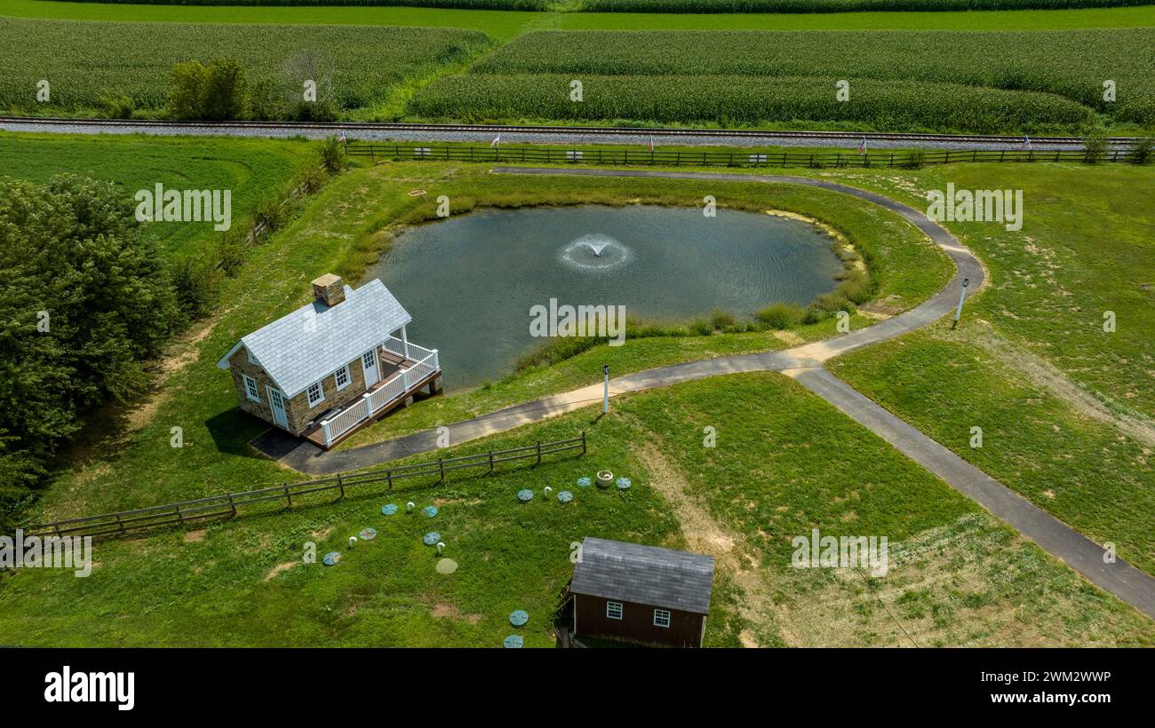 Aerial View Of A Small Pond With A Fountain Next To A Two-Story House ...