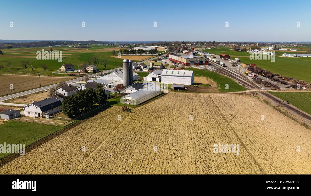 Aerial View Of A Farm Complex With Multiple Barns, Silos, And Plowed ...