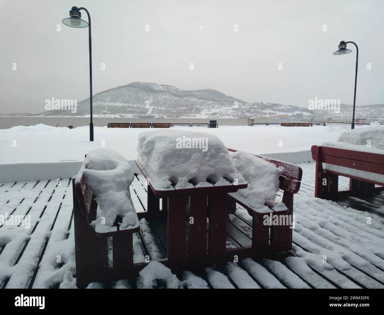 Benches are covered with a thick layer of snow on the shore of ...