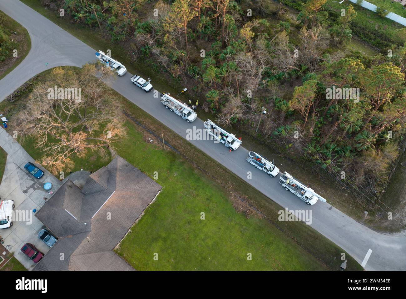 Electrician workers repairing damaged power lines using bucket trucks ...