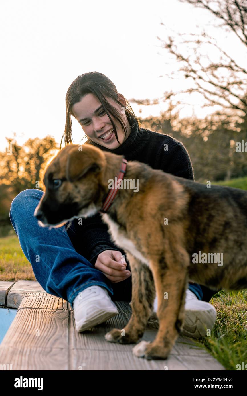 Portrait of a young girl sitting on the floor smiling while looking at ...